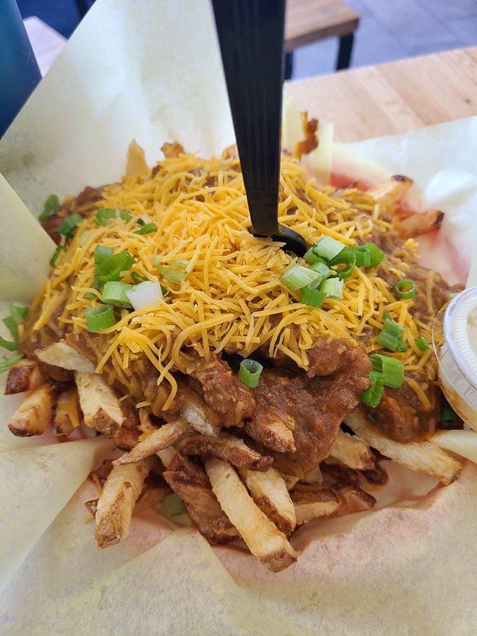 Chili cheese fries: where crispy potatoes surrender to a blanket of chili, cheese, and green onions. A fork is recommended, but determination works too.