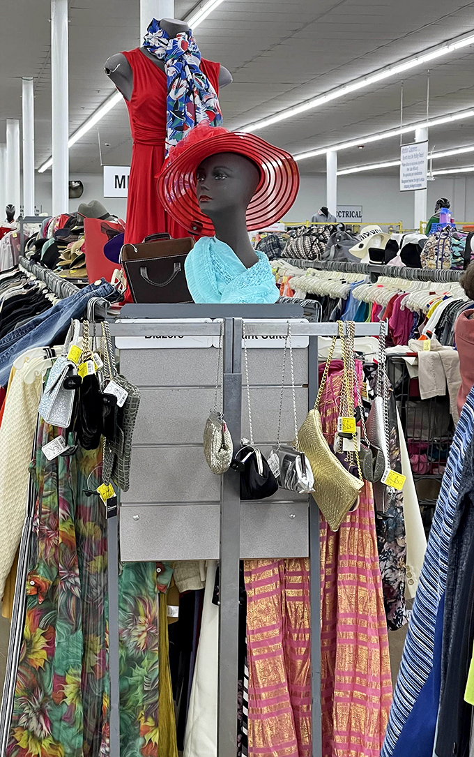 A mannequin sporting a dramatic red dress and wide-brimmed hat stands sentinel over purses that once accompanied their owners to important occasions.