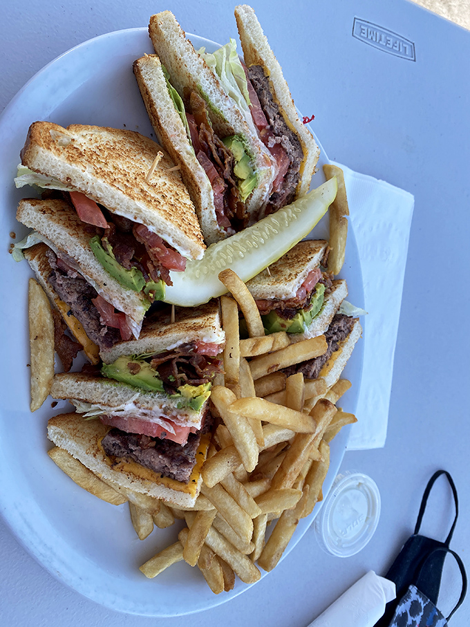 The club sandwich stands tall and proud, a architectural marvel of bacon, lettuce, and toasted perfection.