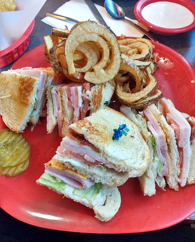 The club sandwich stands tall and proud, layers stacked higher than a New Mexico mesa, with onion rings that could double as delicious golden halos.