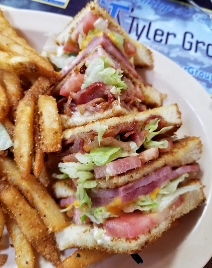 This triple-decker club sandwich towers like a delicious skyscraper, engineered for maximum flavor and structural integrity on your plate.