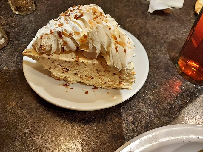 A slice of coconut cream pie that doesn't care about your diet plans, topped with a cloud of whipped cream that deserves its own zip code.