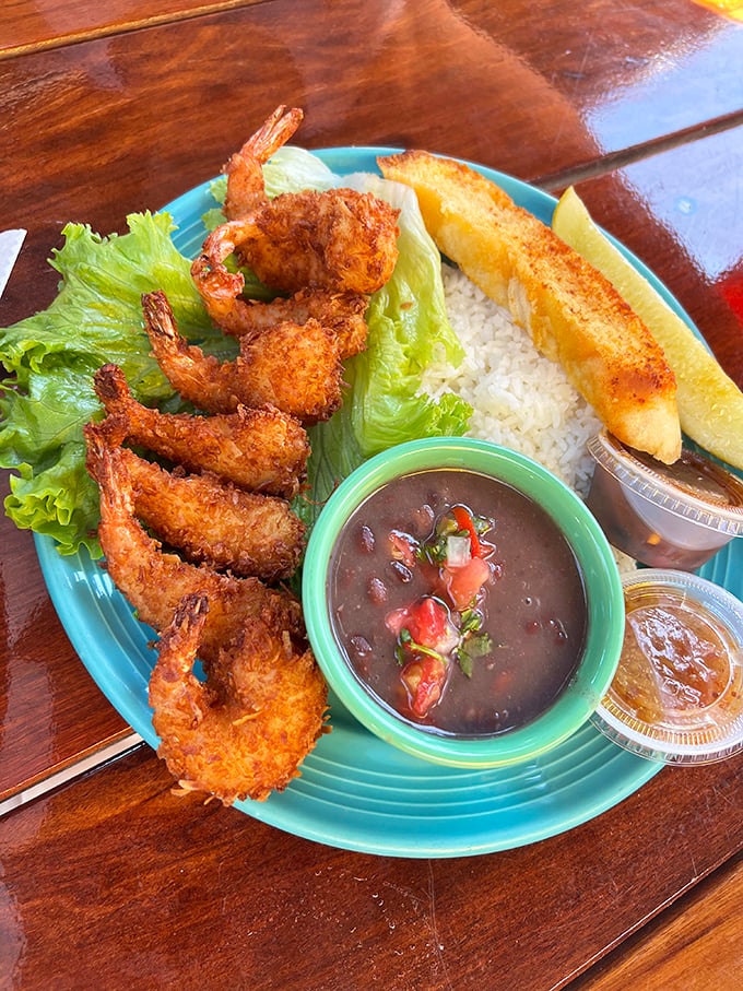 Coconut shrimp so perfectly golden they could win medals, served with rice and black beans that aren't just supporting actors.