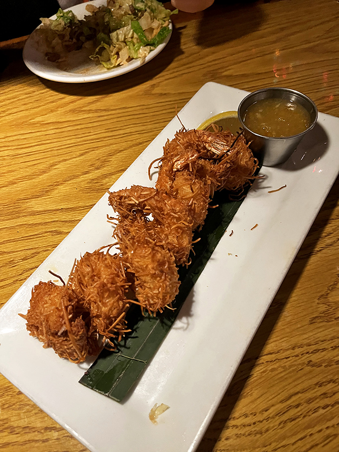 Coconut shrimp that look like they're wearing tiny tropical tuxedos. The dipping sauce is the perfect dance partner for these crunchy crustaceans.