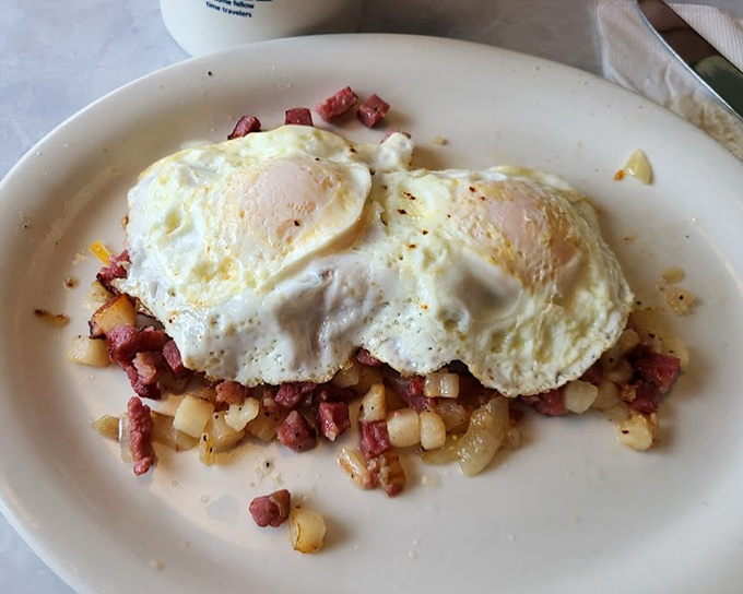 Eggs lounging atop a bed of corned beef hash like royalty. This is breakfast with serious intentions.