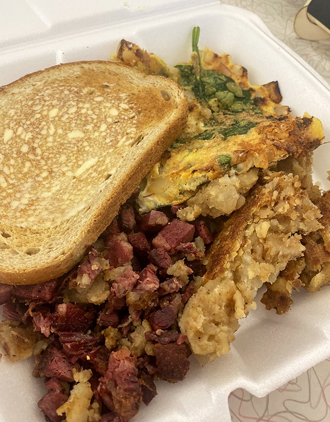 Corned beef hash with that perfect crisp-tender balance, alongside an omelet that clearly didn't skip egg day at the gym.