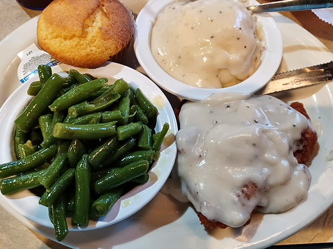 Country-fried steak smothered in gravy, with green beans glistening with a hint of bacon. The kind of plate that makes you want to hug the cook.