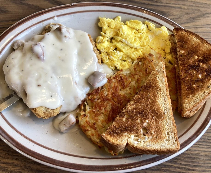 Country fried steak drowning in gravy represents everything right about breakfast, proving white sauce fixes most life problems.