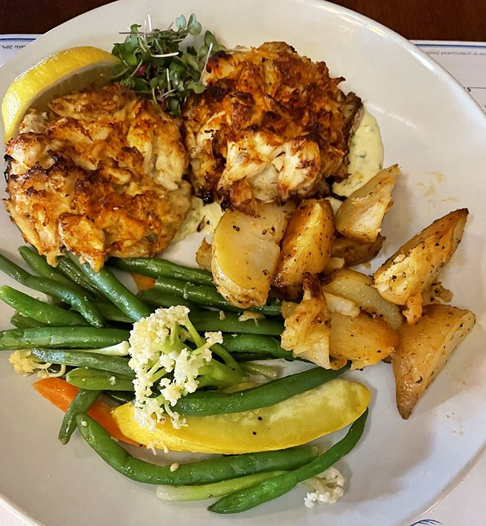 Crab cakes that are actually crab, imagine that! Golden-brown perfection alongside roasted potatoes and fresh vegetables &ndash; the holy trinity of seafood satisfaction.