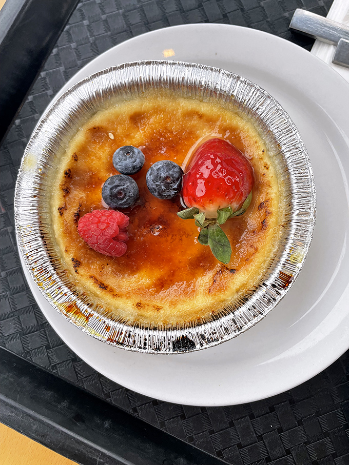 Cr&egrave;me br&ucirc;l&eacute;e with fresh berries&mdash;where the gentle "crack" of caramelized sugar gives way to silky custard beneath, creating that perfect textural tango in every spoonful.