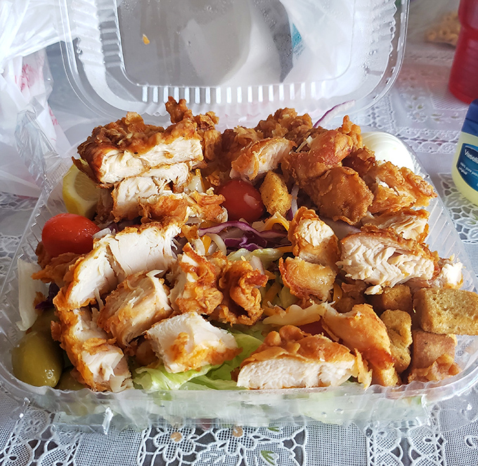 Crispy chicken pieces lounging on a bed of fresh greens&mdash;like tiny sunbathers who accidentally fell into a garden party.