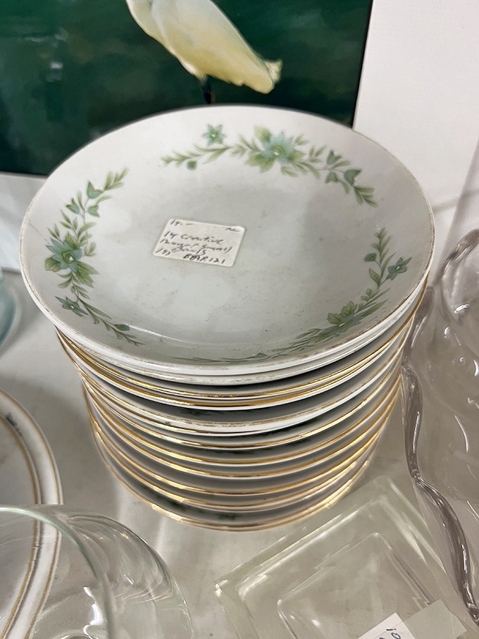 Delicate china stacked with care&mdash;someone's "good dishes" now waiting for a new home to impress dinner guests.