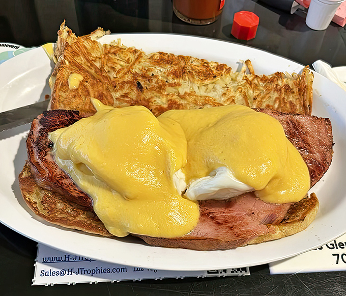 Eggs Benedict bringing that hollandaise perfection with hash browns that know exactly what they're doing on that plate.