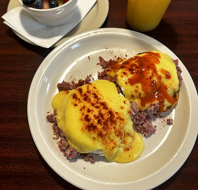 These Eggs Benedict aren't just breakfast – they're two golden-crowned monarchs ruling over a kingdom of crispy potatoes.