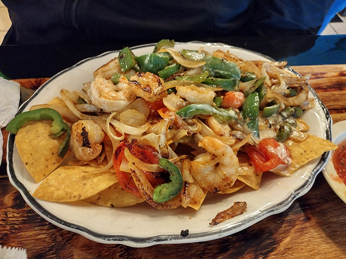 A fiesta of shrimp, peppers, and onions playing together on a bed of tortilla chips. It's like a party where everyone actually showed up!