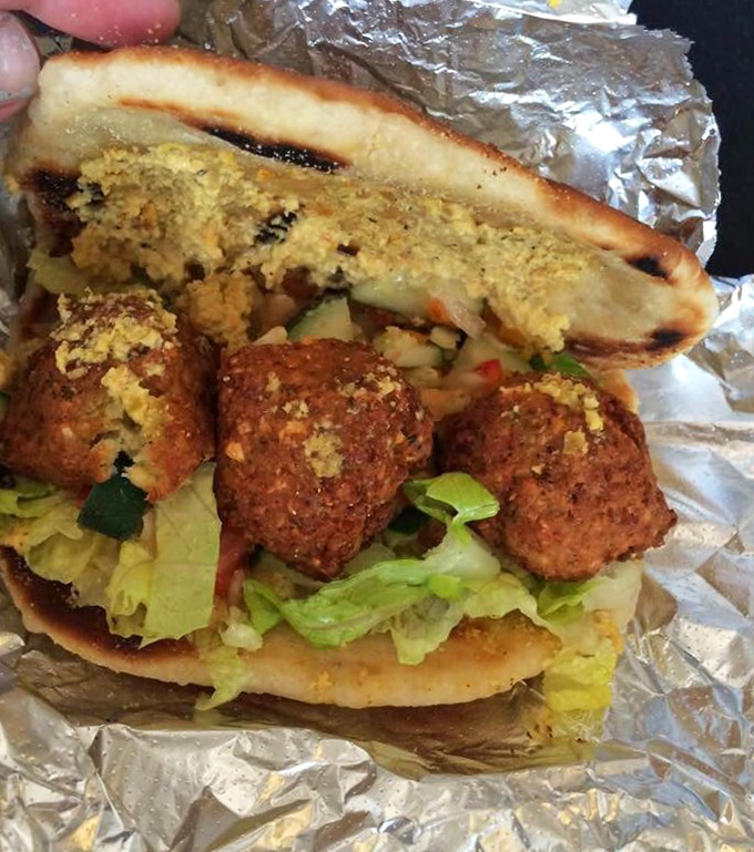 Golden-brown falafel nestled in pillowy flatbread with crisp vegetables. Middle Eastern perfection that makes you forget you're in Indiana, not Israel.