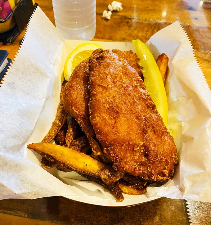 Golden-battered fish rests on a bed of hand-cut fries. The perfect fish and chips doesn't shout&mdash;it whispers of seaside afternoons and newspaper-wrapped treasures.