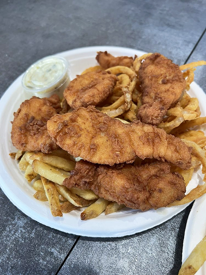 Fish and chips done right—crispy, golden batter protecting flaky white fish, with fries standing by for the essential one-two punch of seafood satisfaction.