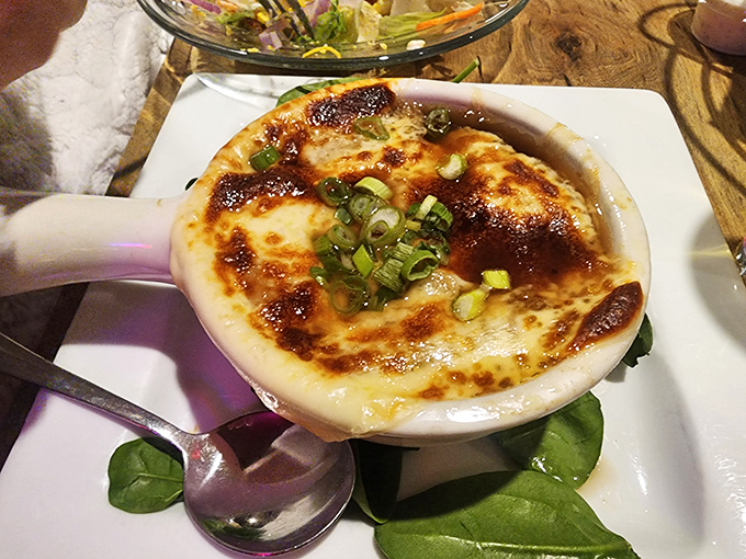 This French onion soup isn't just topped with cheese &ndash; it's wearing a golden crown that would make royalty jealous.