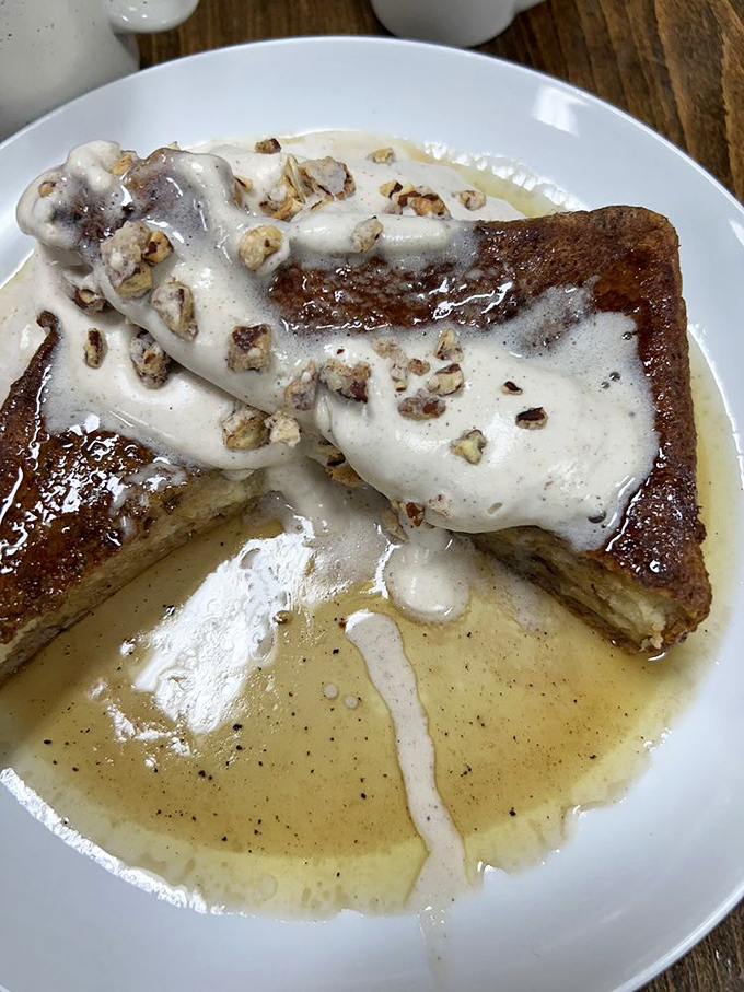 This French toast isn't messing around. Topped with what appears to be candied pecans and drowning in maple goodness, it's breakfast's final boss level.