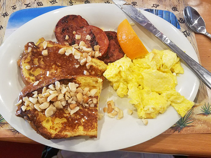French toast dusted with powdered sugar and topped with macadamia nuts, paired with Portuguese sausage&mdash;a sweet and savory island romance on a plate.