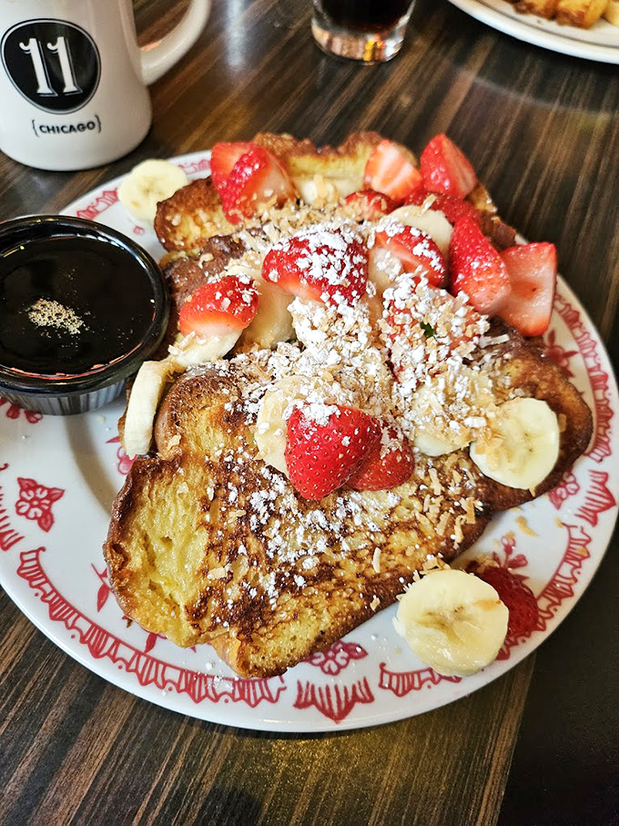 Challah French toast adorned with fresh berries and powdered sugar&mdash;breakfast that makes you question why other meals even exist.