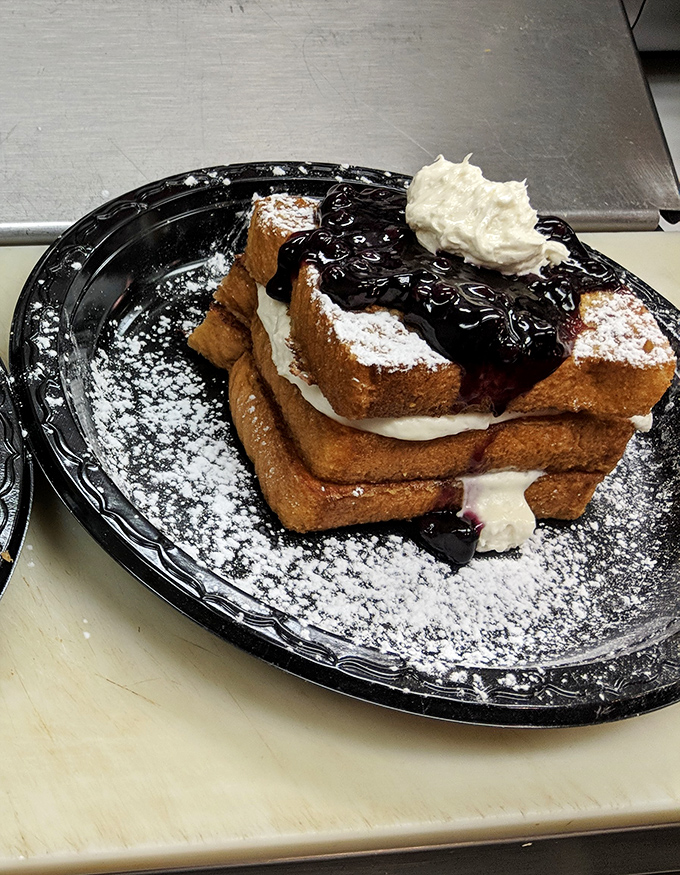 Breakfast that doesn't know what time it is. This towering French toast creation, crowned with berries and cream, is available all day.
