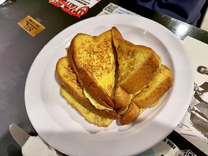 Golden French toast stacked high, each slice a custard-soaked canvas waiting for the maple syrup artist in you.