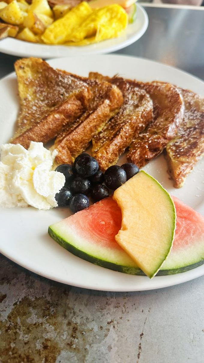 French toast that's dressed better than most people at breakfast. The fresh fruit side isn't just healthy&mdash;it's your conscience's way of approving indulgence.