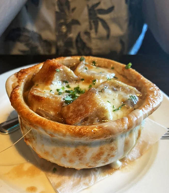 This isn't just French onion soup - it's a cheese-capped volcano of savory broth that's been simmering since before your last birthday.