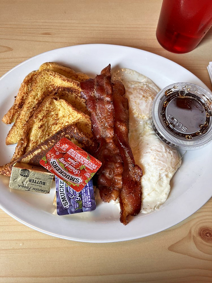 The breakfast trinity: perfectly crisped bacon, golden toast, and eggs that belong in the Sunny Side Up Hall of Fame.