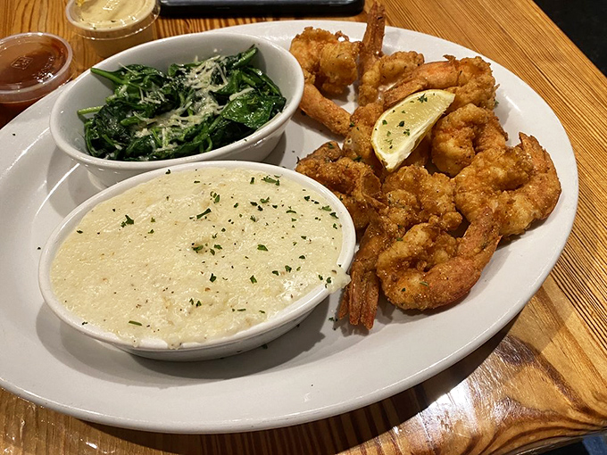 These aren't your average shrimp &ndash; they're crispy-coated celebrities of the sea, served with greens and grits that make vegetables exciting again.