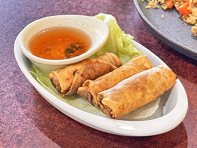 Crispy fried spring rolls emerge from the kitchen golden and ready to be dunked into that sweet chile sauce waiting patiently.