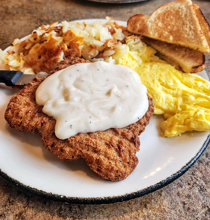 Country fried steak smothered in peppery gravy alongside sunshine-yellow eggs and crispy potatoes&mdash;the breakfast trifecta that launched a thousand naps.