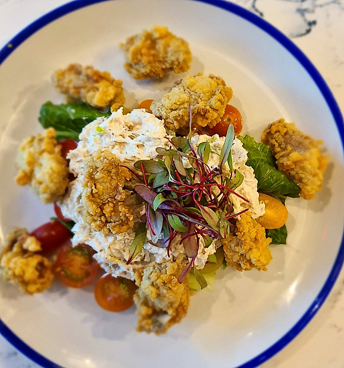 Fried oysters surrounded by microgreens and a creamy centerpiece. Ocean treasures transformed into crispy, briny bites of heaven.