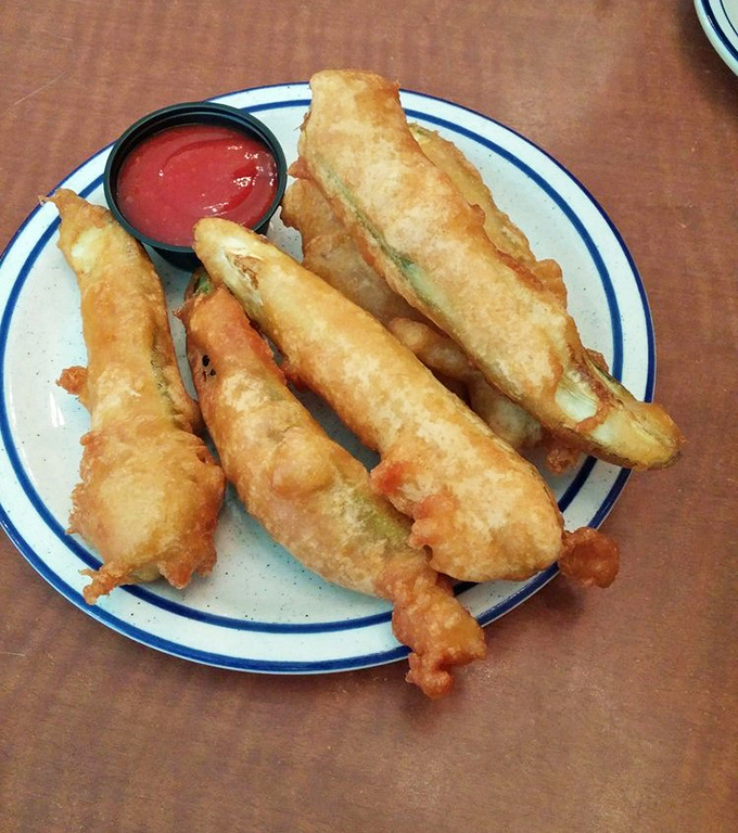 Golden-fried pickle spears that shatter with each bite, revealing a juicy center. The perfect companion to that cold drink waiting just out of frame.