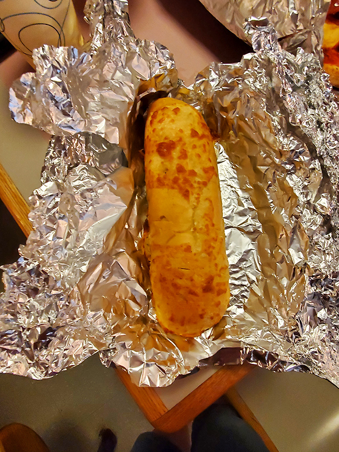 Golden garlic bread emerging from its foil cocoon, ready to make all your carb-loving dreams come true.