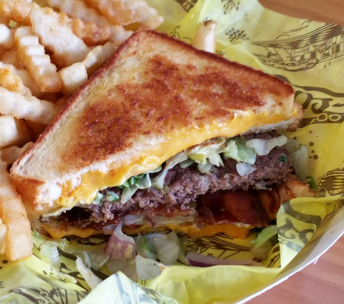 This isn't just a sandwich; it's a grilled cheese masterpiece with burger benefits, served on a wrapper that doubles as your napkin.