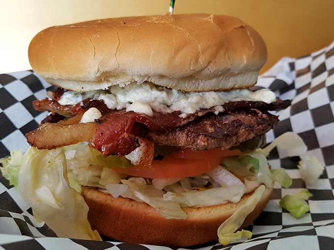 This isn't just a burger&mdash;it's architecture. The careful stacking of beef, bacon, and fresh veggies creates a towering achievement that requires both hands and zero shame.