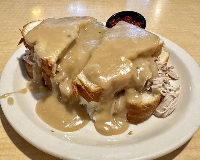 The open-faced hot turkey sandwich: bread buried beneath a turkey avalanche and gravy lava flow, with cranberry sauce standing by for sweet-tart rescue.