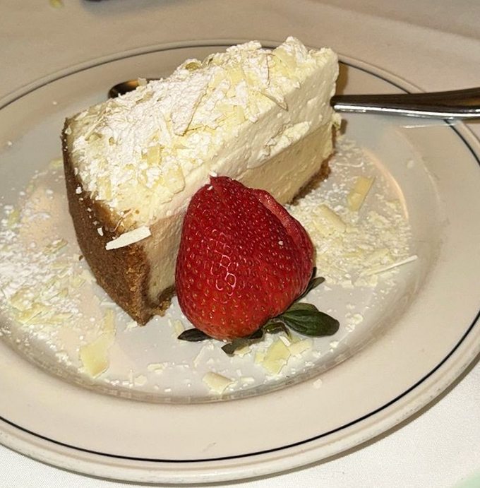 Cheesecake with a strawberry sentinel standing guard. One bite and you'll understand why people save room when they're already full.