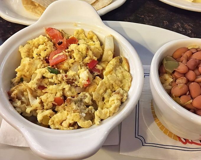 Scrambled eggs studded with fresh vegetables alongside beans &ndash; proof that breakfast knows no borders at this neighborhood gem.