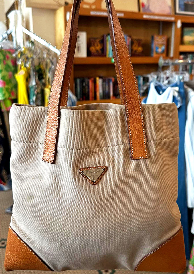 A Prada canvas tote with leather trim waits patiently for its second act&mdash;proof that luxury labels regularly make surprise appearances among the racks.