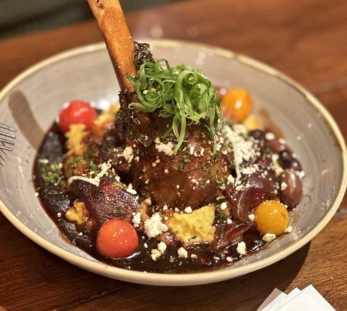 A lamb shank that's had a more luxurious bath than most people, swimming in a rich reduction with colorful vegetable companions.