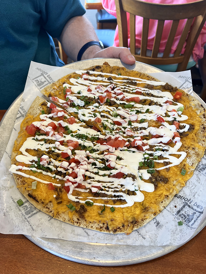 The loaded cheese crisp arrives like a savory sunburst on your table. That drizzle of sour cream is the chef's signature.