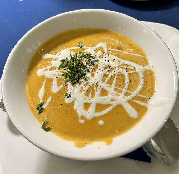 This lobster bisque isn't just orange &ndash; it's a sunset-colored pool of velvety decadence with artistic cream swirls worthy of a gallery.