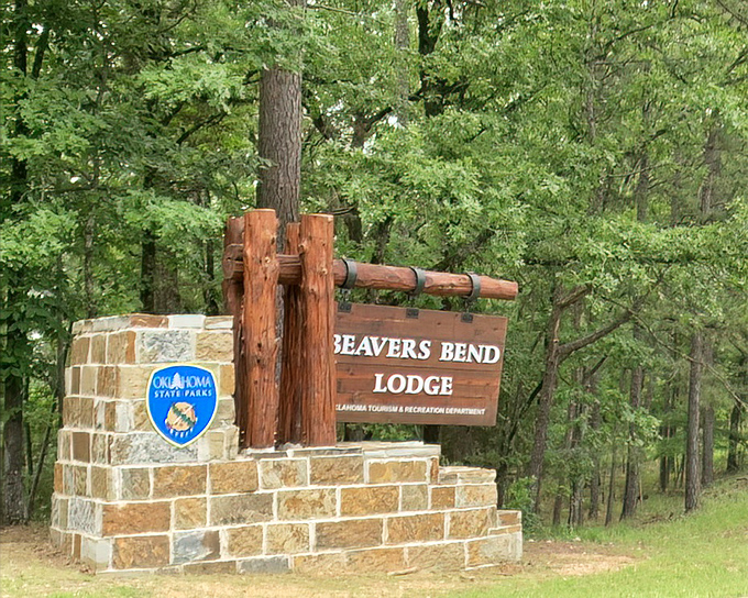 The Beavers Bend Lodge sign stands sentinel among the pines, promising rustic comfort without sacrificing your Wi-Fi addiction.