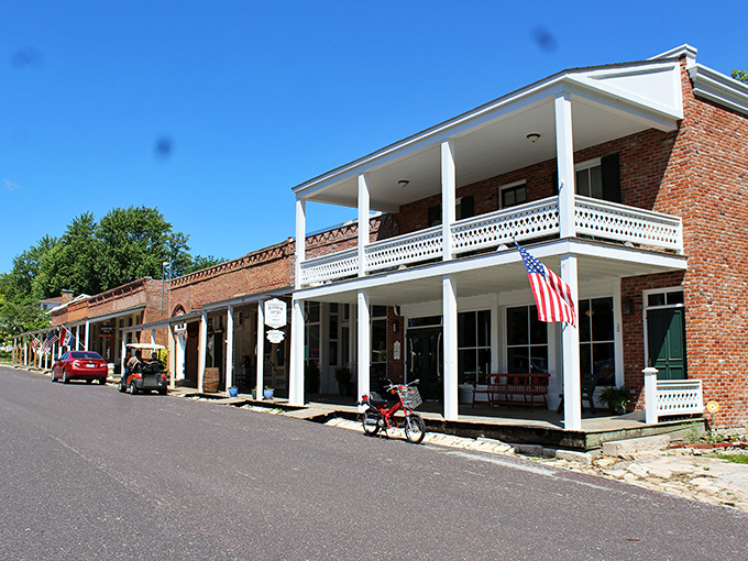 Arrow Rock's historic storefronts stand shoulder to shoulder, a brick-and-mortar timeline where modern cars park alongside 19th-century architecture.