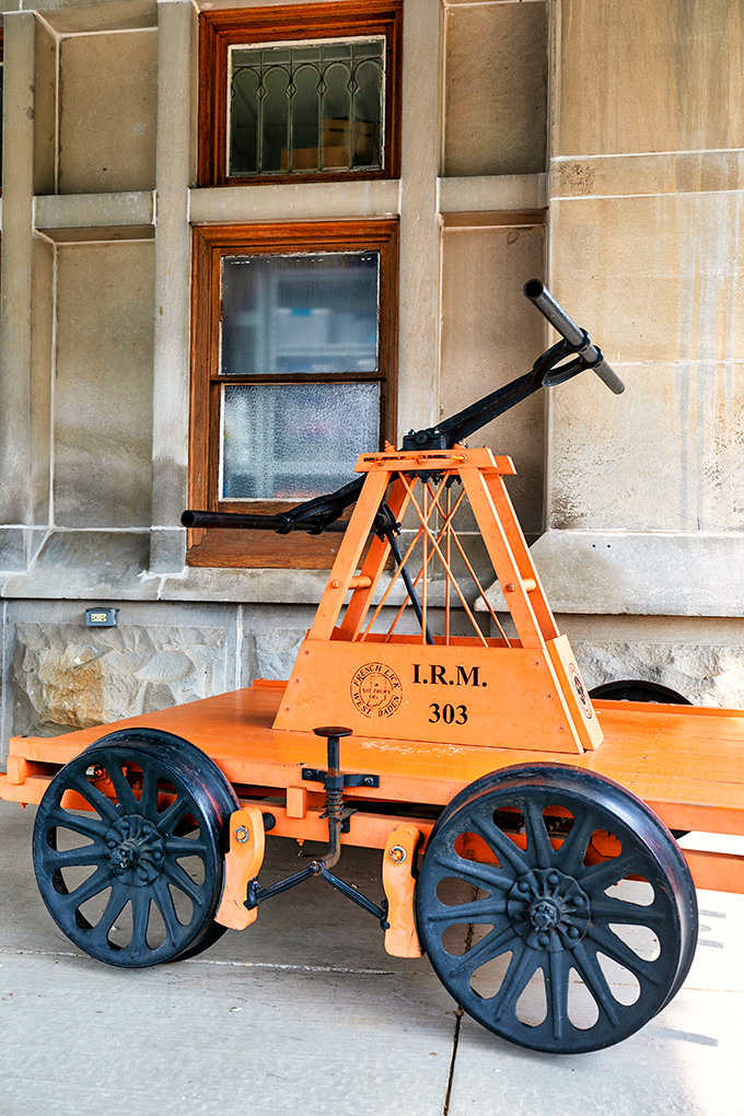 This bright orange handcar isn't just a museum piece—it's a reminder of the ingenious simplicity of early railway maintenance technology.