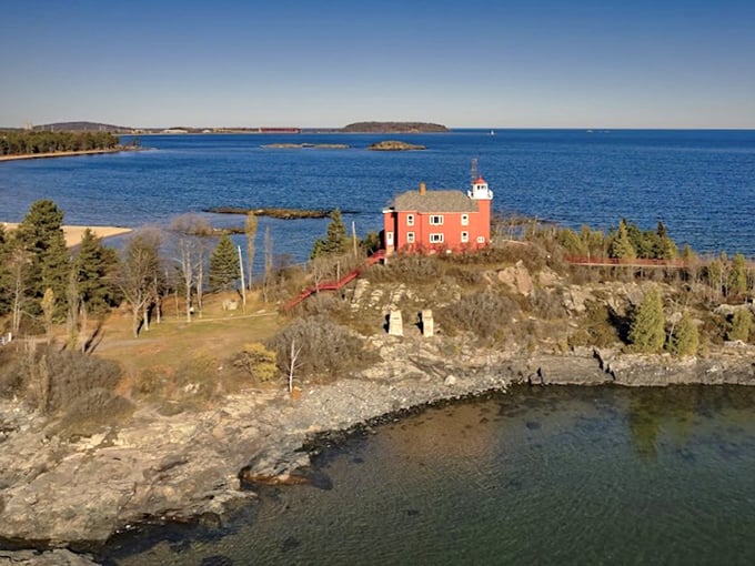 The Marquette Harbor Lighthouse stands proudly on its rocky perch, a crimson sentinel that's been guiding sailors and collecting Instagram likes since 1866.
